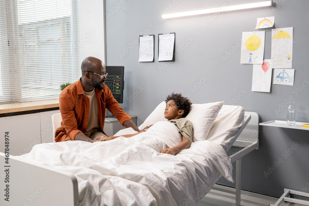African father talking to his little son during his visit while he ...
