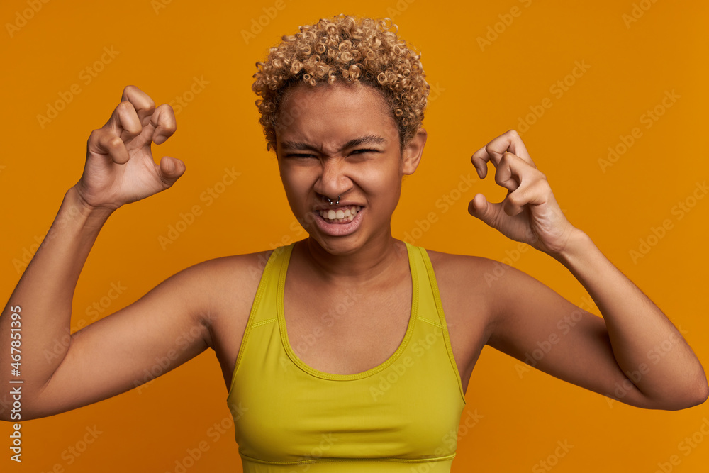 Horizontal studio shot of angry furious dark-skinned woman roaring ...