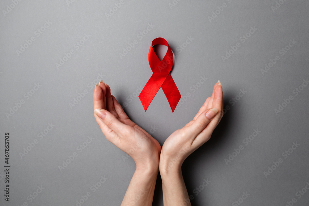 Female's hands frame a red ribbon, a symbol of the fight against AIDS ...