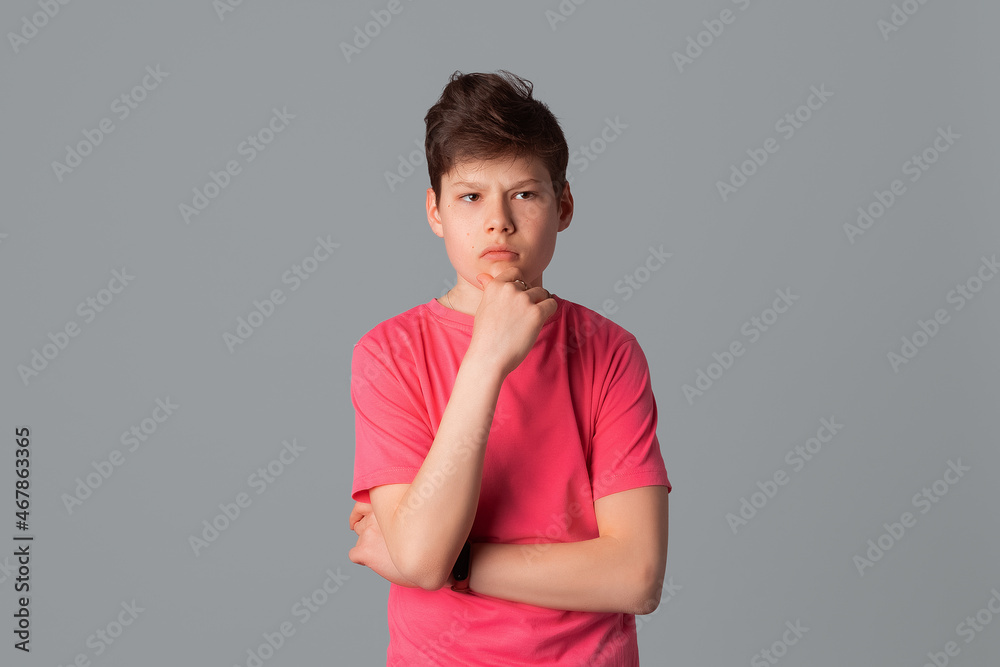 Teenager boy in pink t shirt looking away while thinking, making choice ...