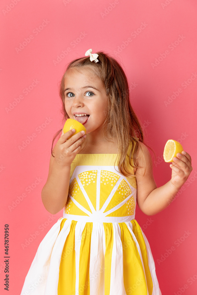 Cute little girl on pink background licking a lemon Stock Photo | Adobe ...