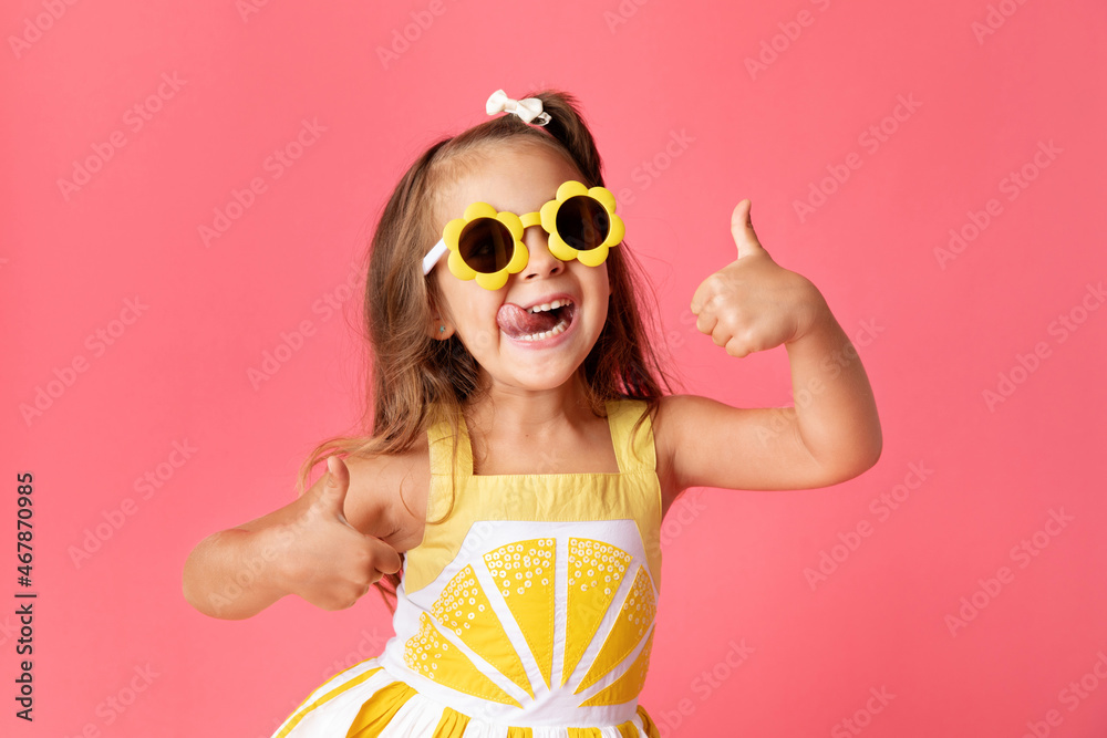 Portrait of silly little girl on pink background making funny face ...