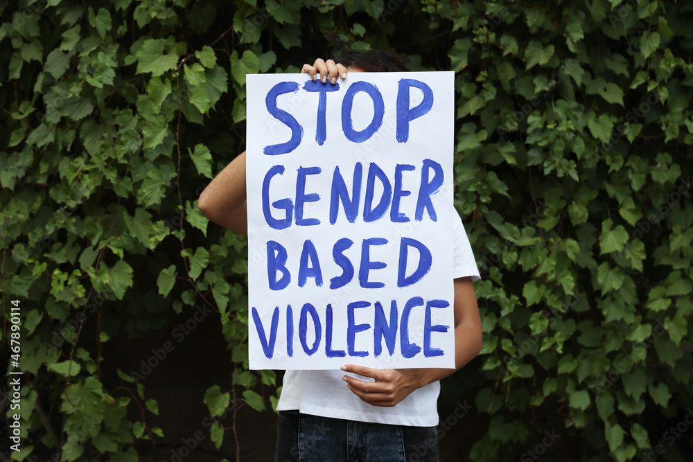 Woman holding sign with text Stop gender based violence outdoors Stock ...
