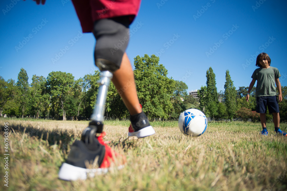 Father with prosthetic leg playing football with son. Man with ...