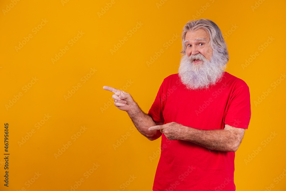 Old man with a long beard pointing to the side on a yellow background ...