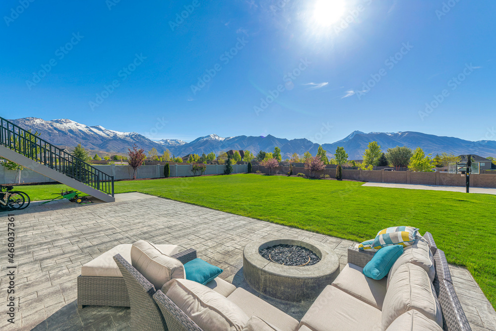 Outdoor patio with a view of a large backyard with basketball court ...