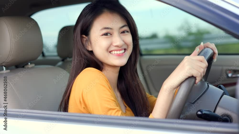 Young beautiful asian women getting new car. she very happy and excited. she sit and touching ...