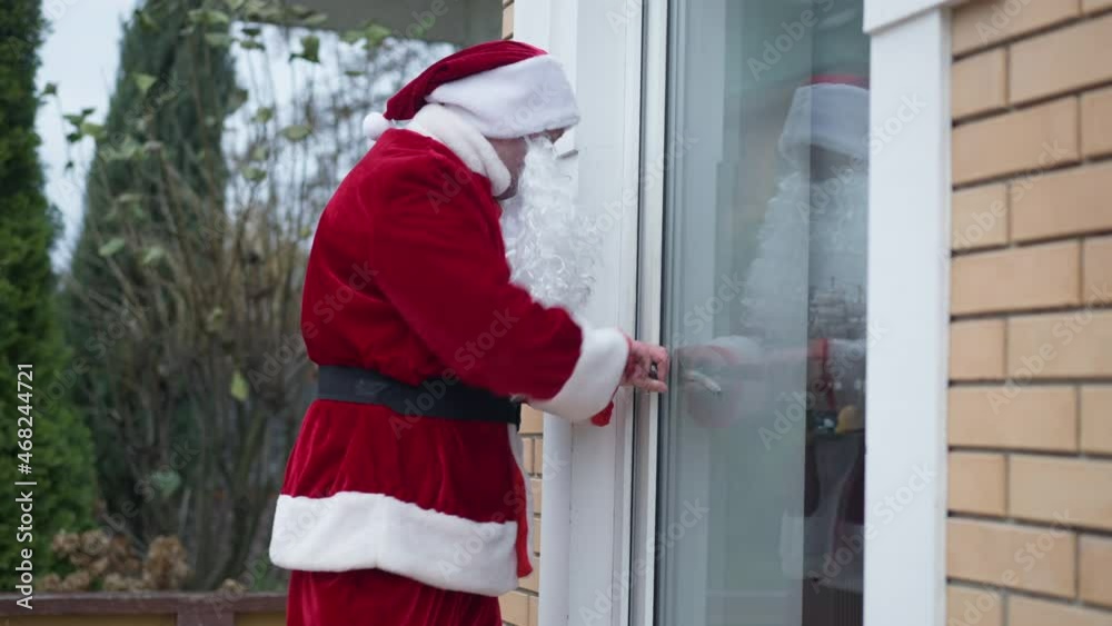 Side view burglar in red costume with white beard looking around ...