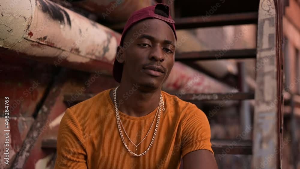 Young black guy in the ghetto. A young man sits on a staircase in an ...