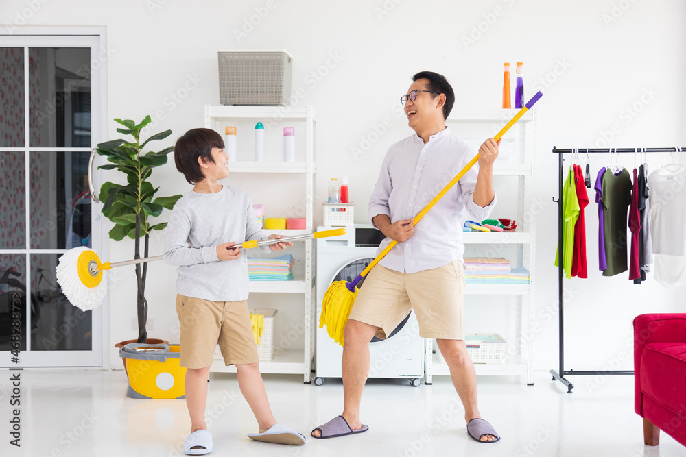 Asian father and son having fun while helping each other to clean the ...