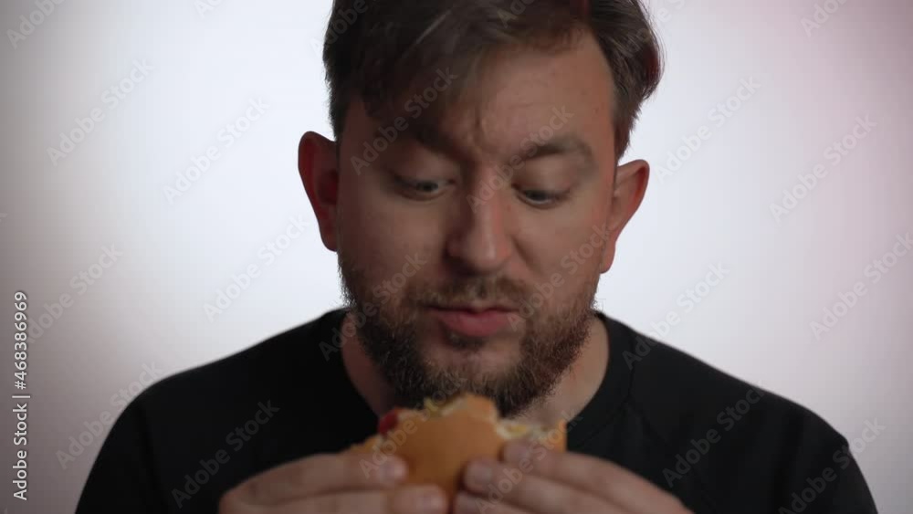 Hungry man eating burger on white background, male biting hamburger ...
