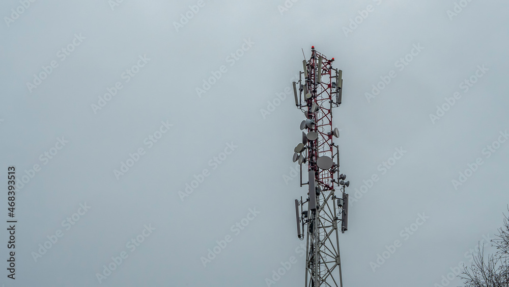 Tower with mobile operator antennas on the dramatic sky background ...