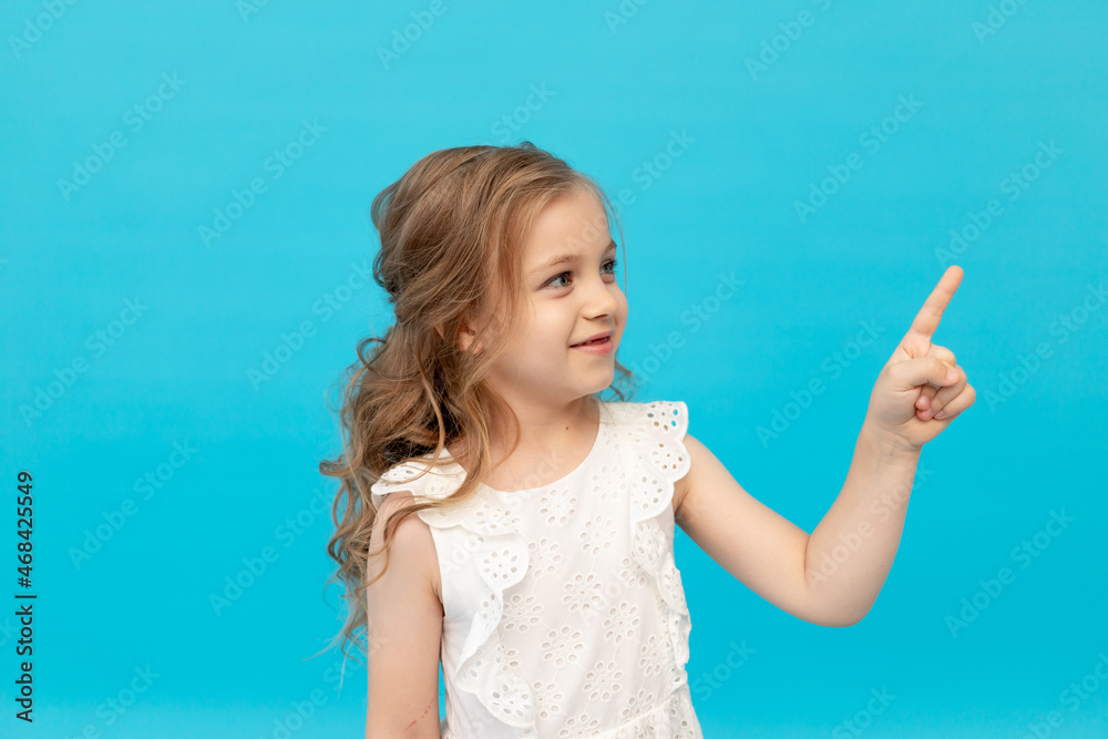 Happy cute little girl in a cotton white dress on a blue background in ...