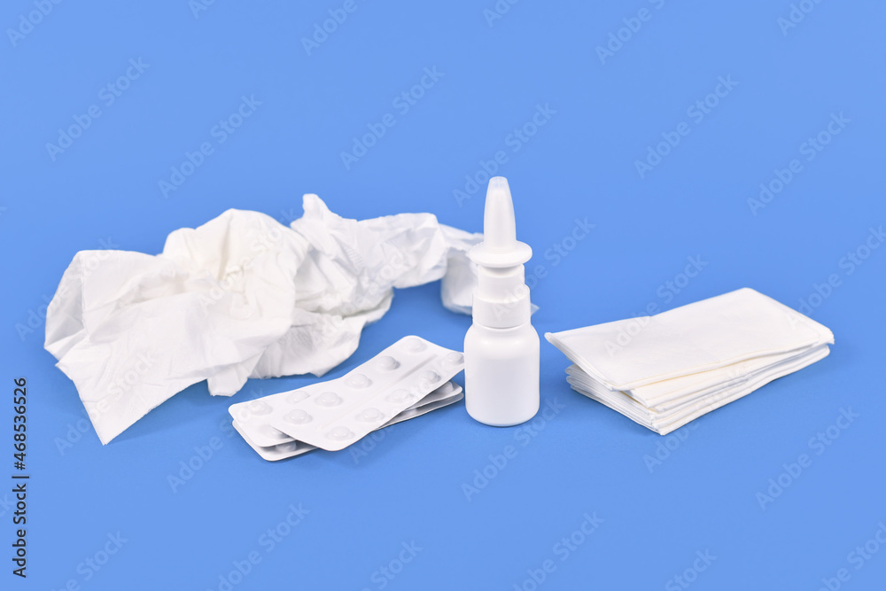 Nasal spray bottle, medicine pills and used tissues used during common ...