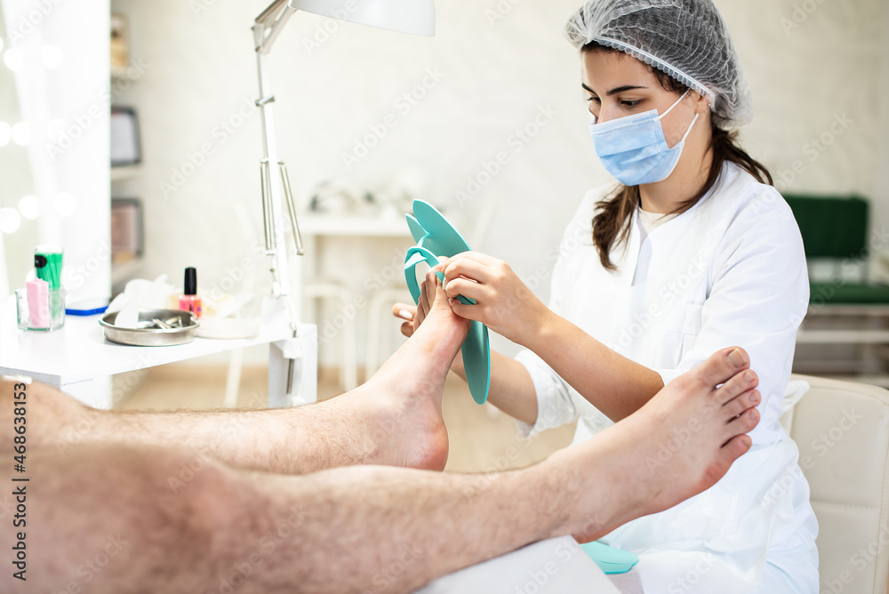 Professional men's pedicure in the salon. Young girl makes a man ...
