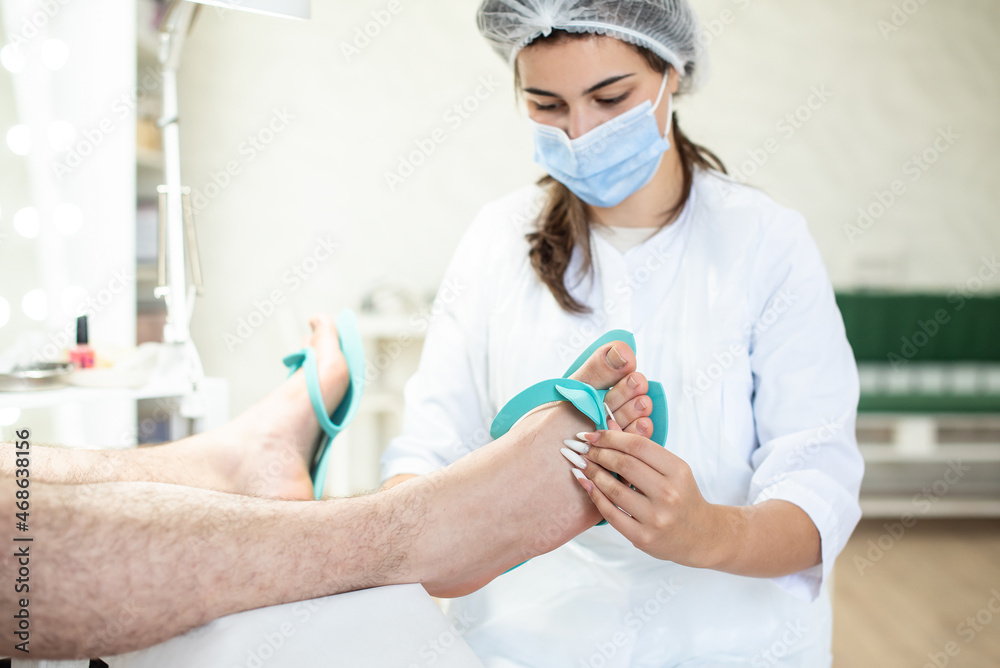 Professional men's pedicure in the salon. Young girl makes a man ...