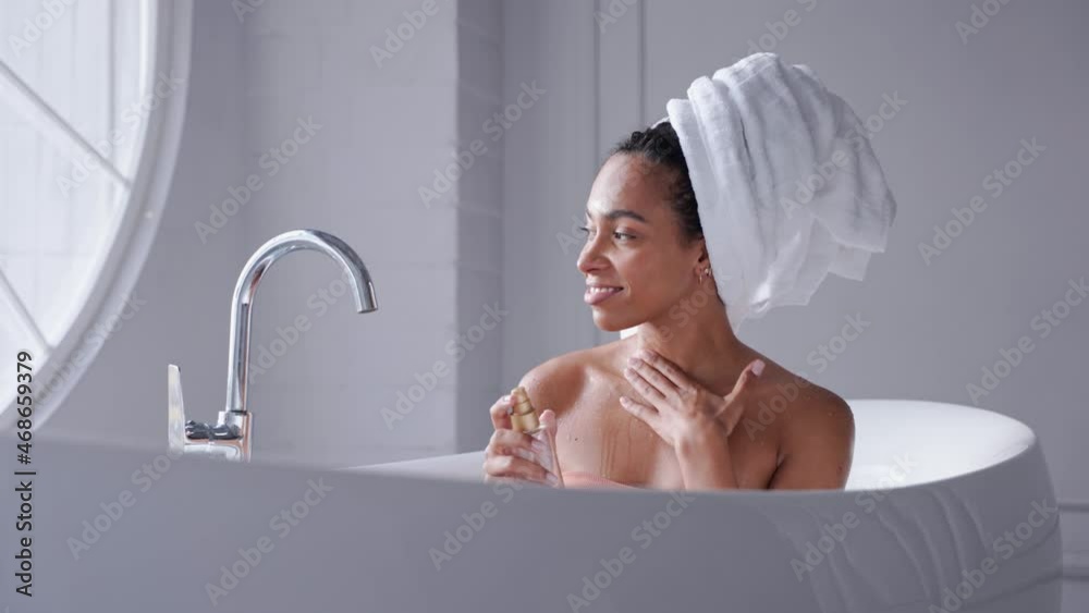 Black woman taking a bath washing her neck and shoulders with her hair ...