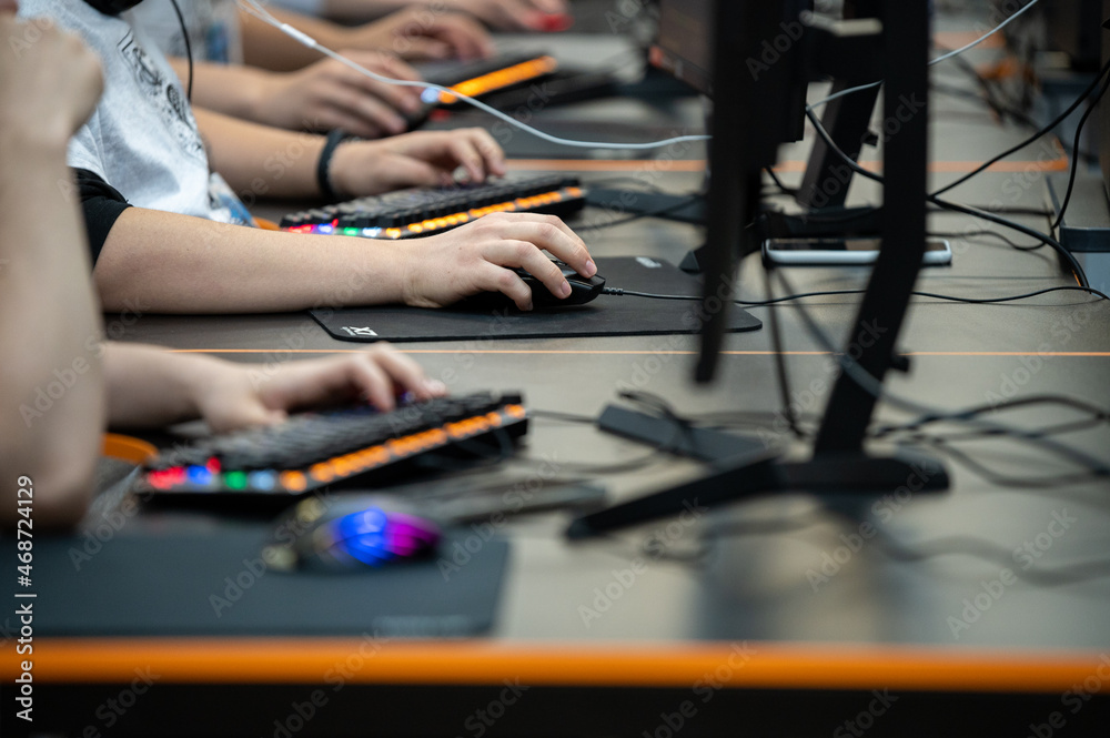 Focus on Hands, Keyboards and Mouse. Back view of young gamer playing ...