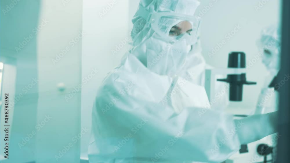 Handheld shot of a Caucasian female researcher in a clean room ...
