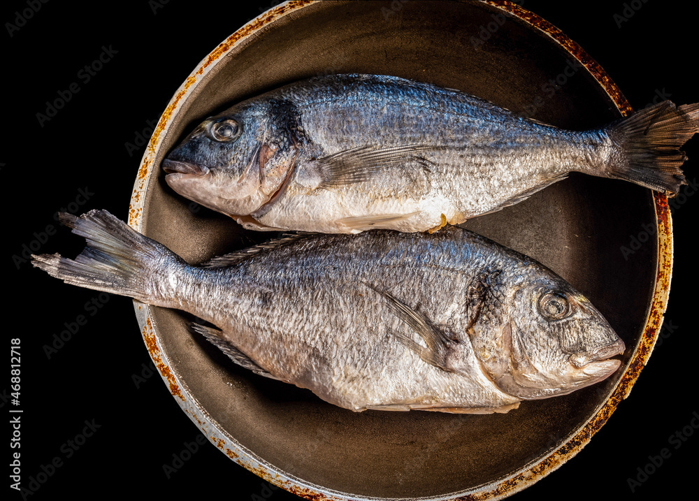 Zwei Doraden Speisefische liegen in der Pfanne und warten auf die ...