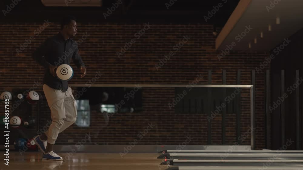 One black African-American man throws a bowling ball and knocks out a ...