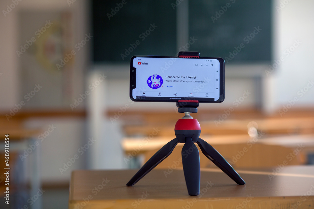 YouTube internet logo on a phone on a desk in a classroom with no ...