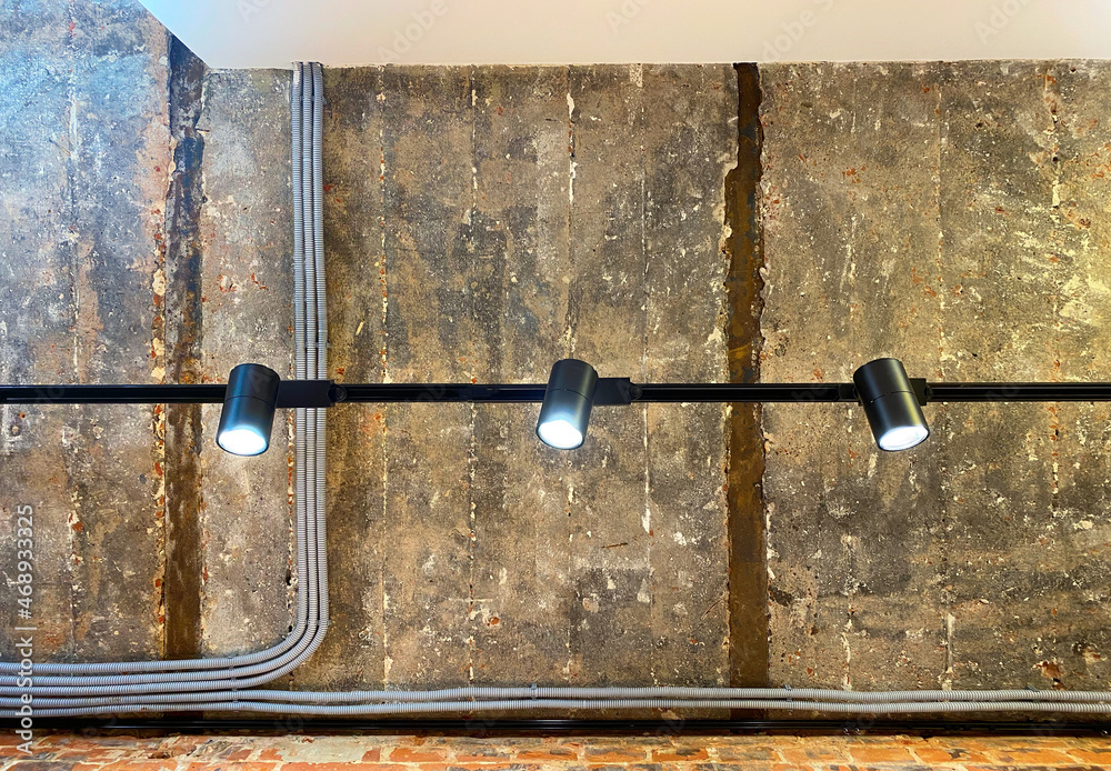 Loft interior style fragment. Black track lights on a concrete ceiling ...