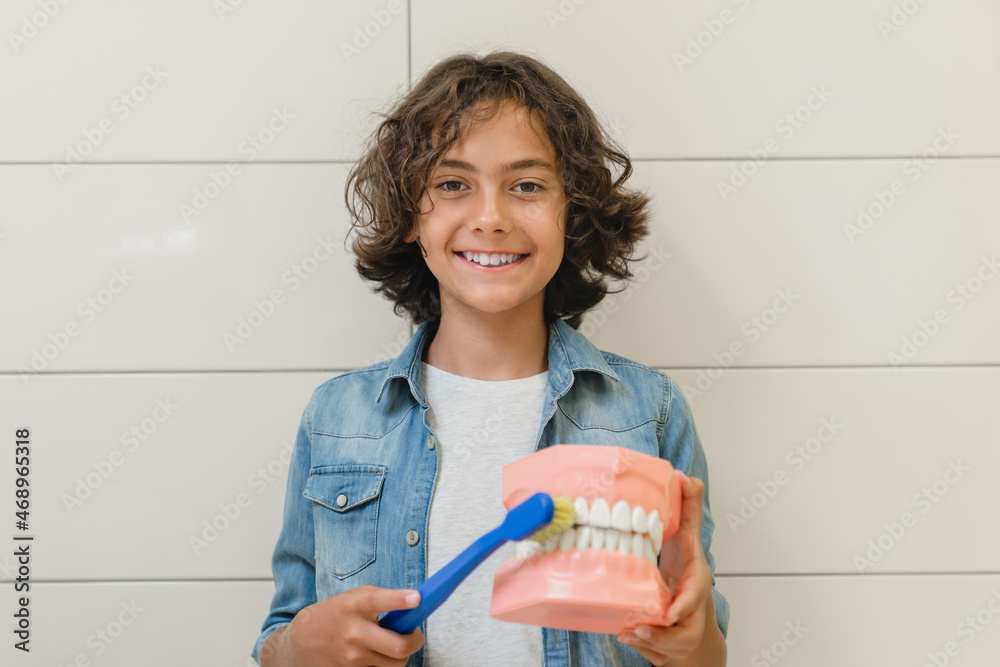 Boy with perfect ideal healthy smile showing how to use tooth brush on ...