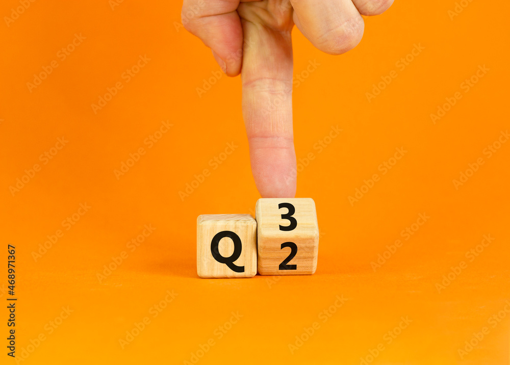 From 2nd to 3rd quarter symbol. Businessman turns a wooden cube and ...
