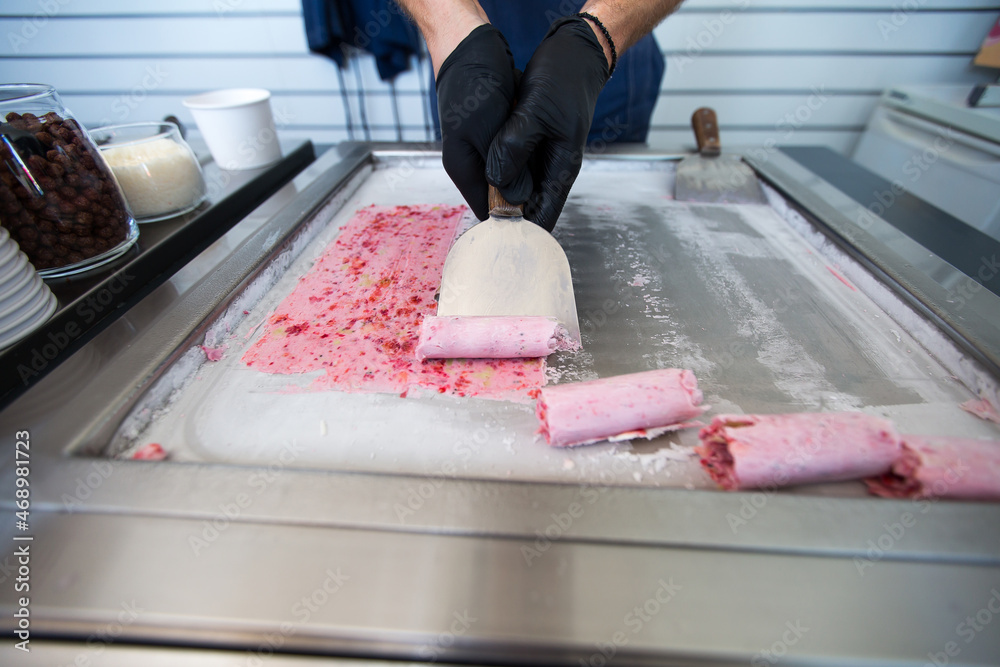 Stir-fried ice cream rolls at freeze pan. Rolled ice cream, hand made ...