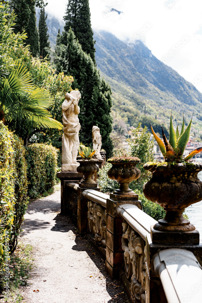 Alley with balustrades and statues near Villa Monastero. Lake Como ...