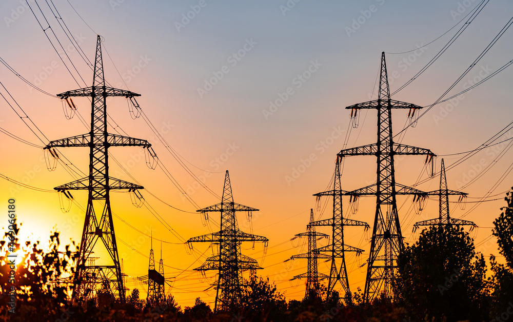 High voltage electric towers at golden sunset. Silhouettes of a number ...