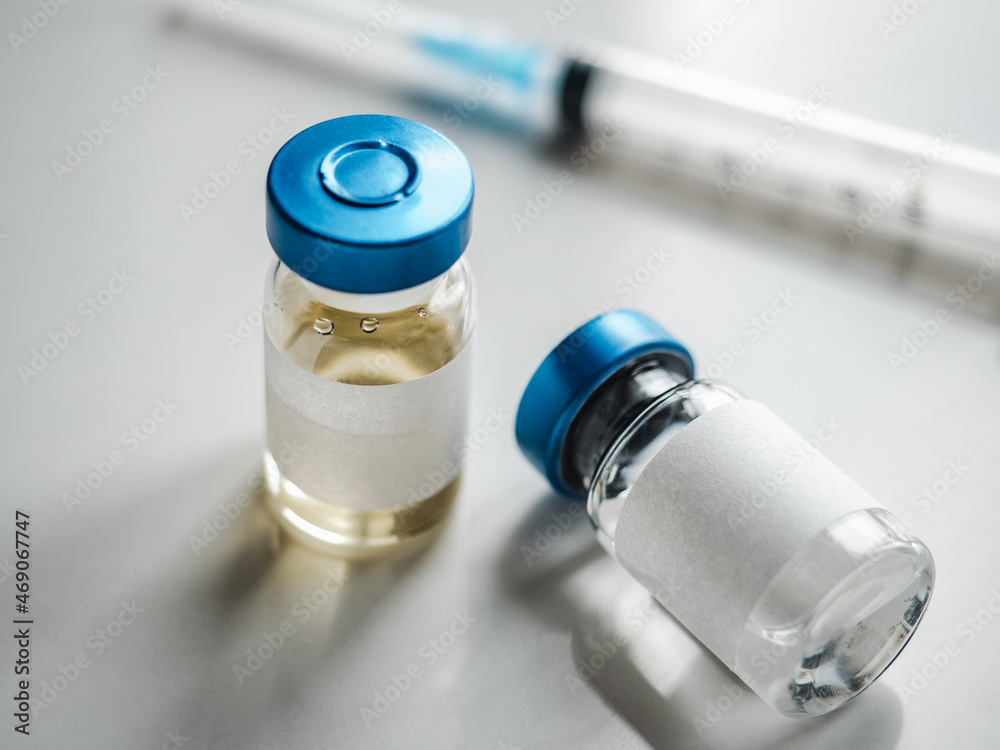 Syringes, injection bottles and tablets lying on the table. Close-up ...