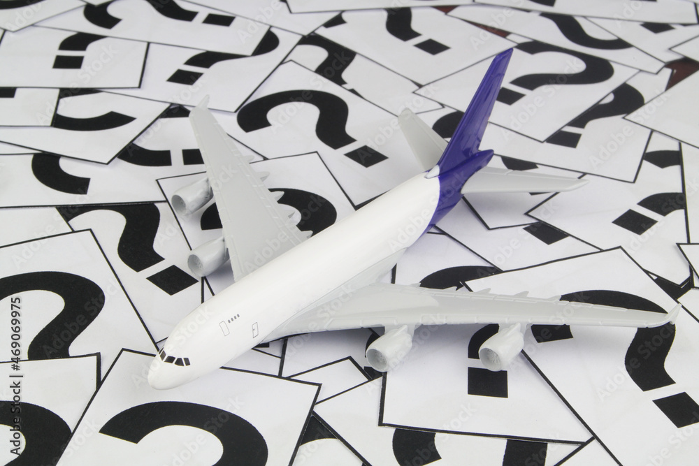 Airplane model on question marks background. Travel and aviation ...