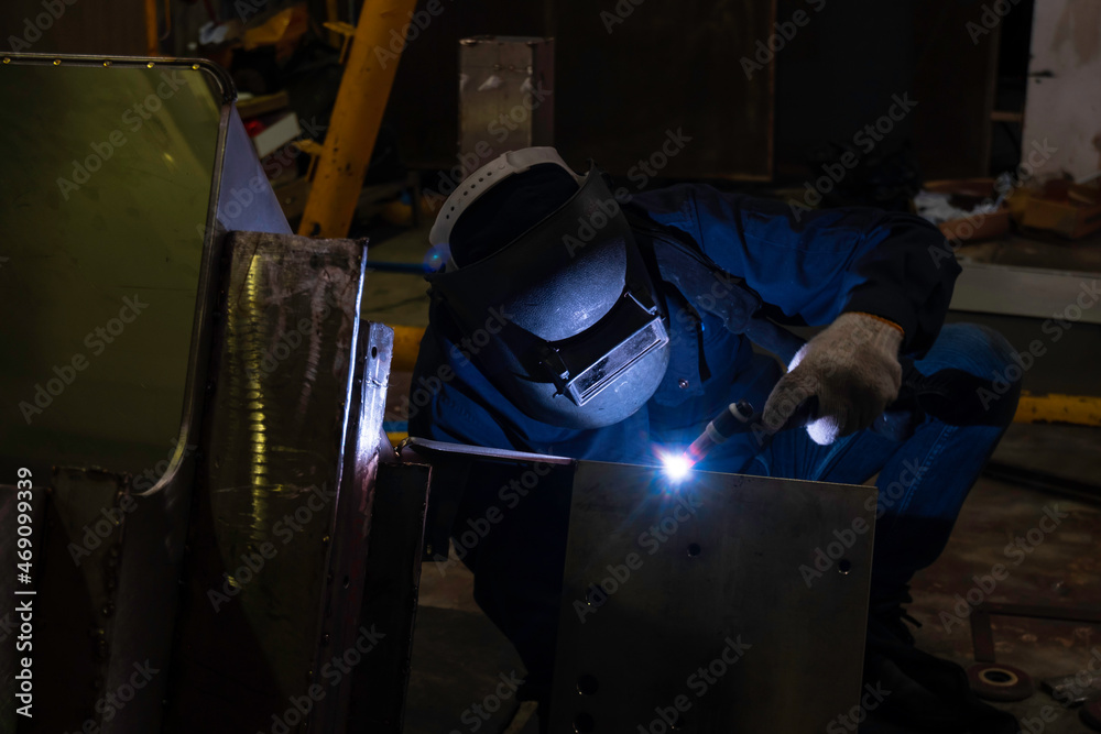 Welder is welding the steel in the factory. Weld the steel in dark ...