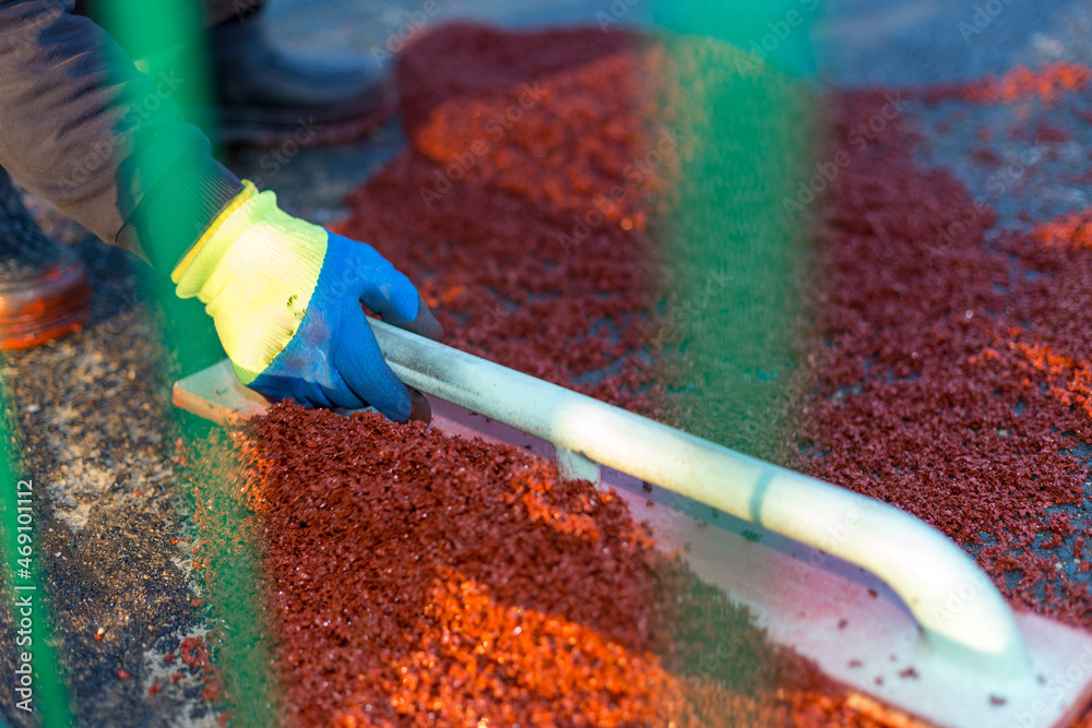 red rubber covering for the playground, the master smoothes the soft ...