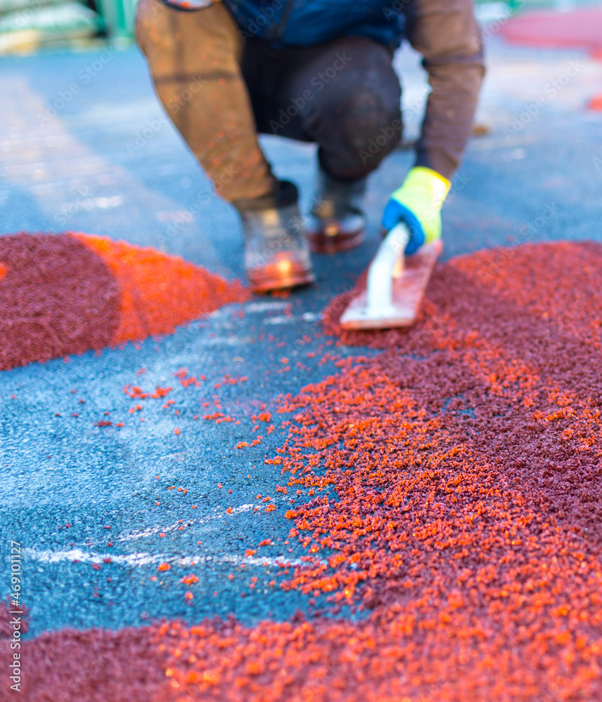 red rubber covering for the playground, the master smoothes the soft ...