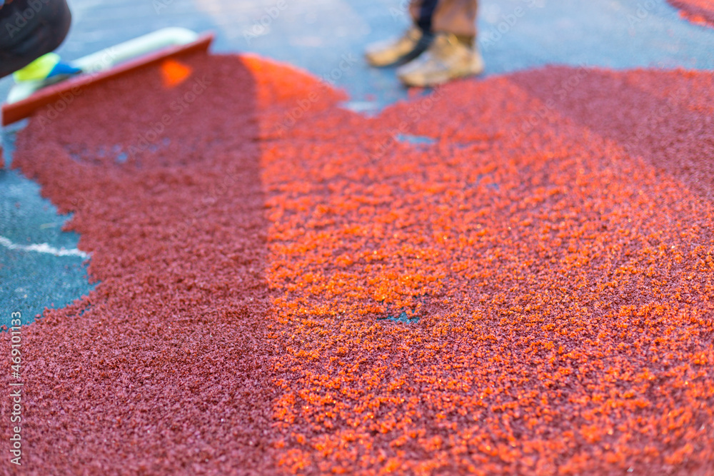 red rubber covering for the playground, the master smoothes the soft ...