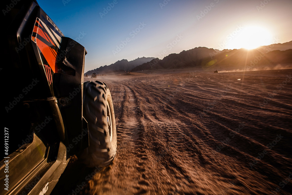 Wheel of a large ATV in the desert. Photo in motion. An important part ...