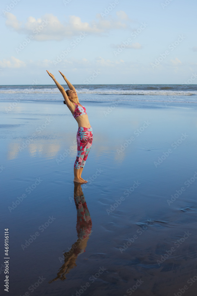 Sun Salutation practice at the beach. Slim woman standing in Hasta ...