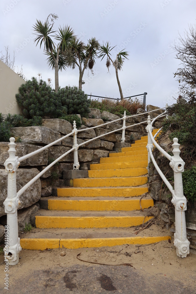 little yellow curved stone steps with metal railings rock walls ...