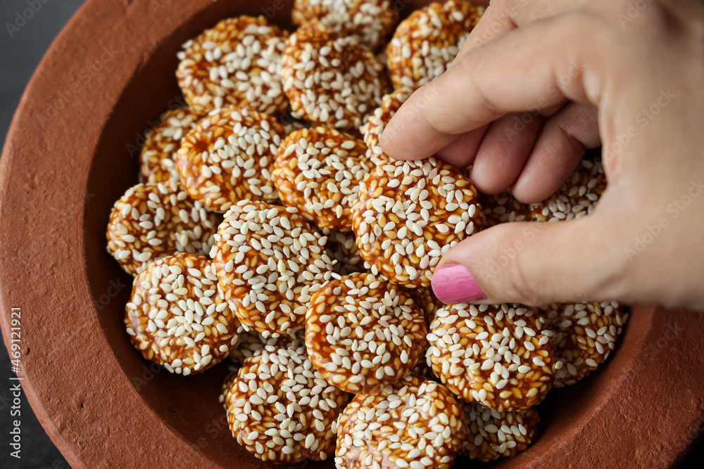 Revdi revri til gud revdi rewari sesame winter food woman hand serving ...