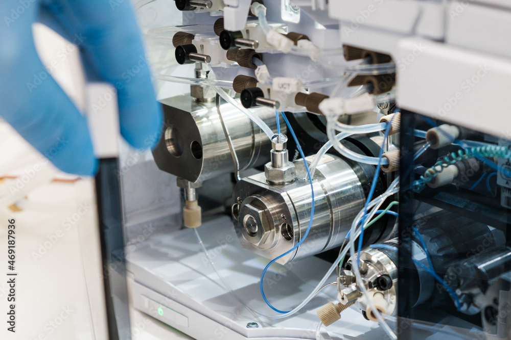 Scientist hand opens the door with binary pump for mixing for HPLC ...