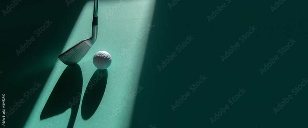 White golf ball and stick with natural lighting on mint background ...
