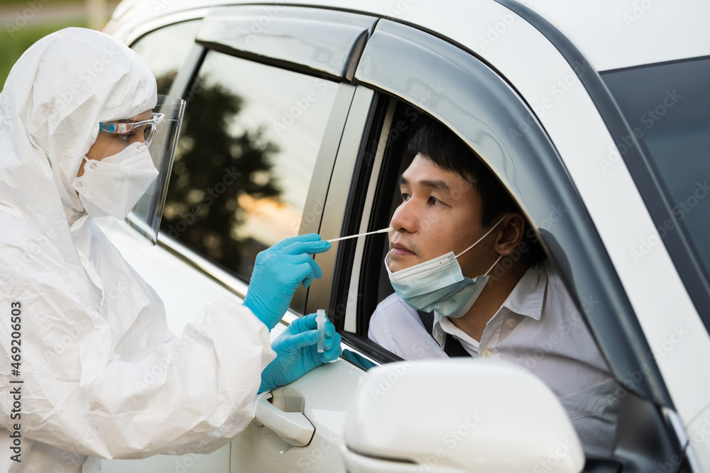 doctor in PPE suit test coronavirus(covid-19) to man in car by nasal ...