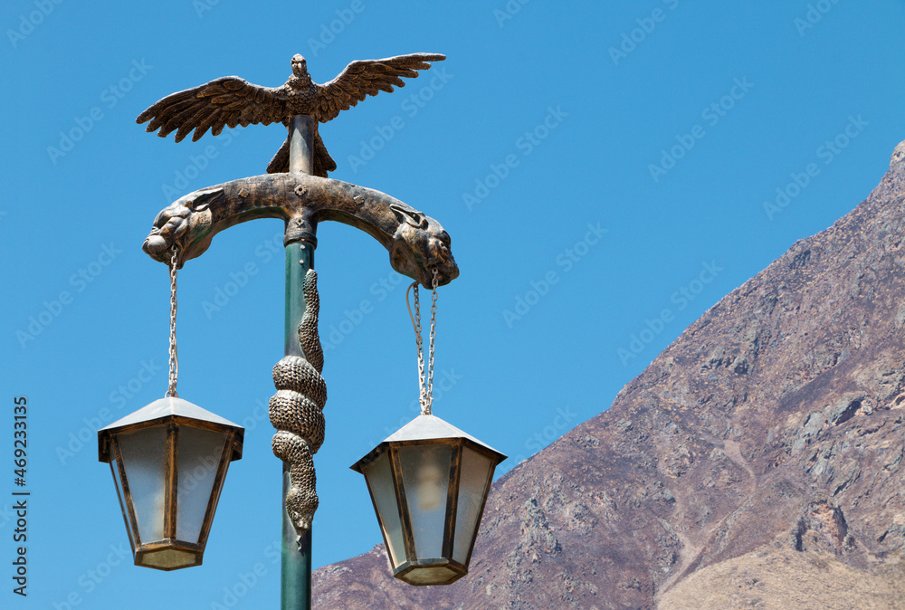 Antique lamp post with a metal sculpture of a puma eagle and a sacred ...