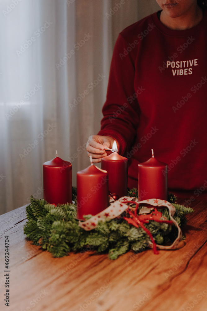 Child hand lighting the first candle of Advent Wreath on the first ...