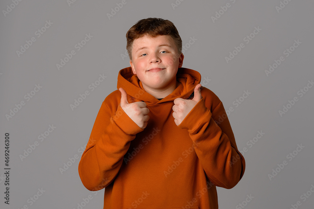 Cheerful teenager boy shows thumbs up, happy face, give compliment ...
