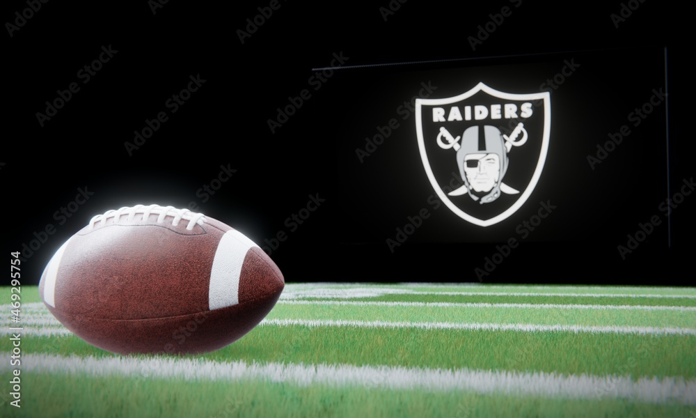 American football in foreground with logo of NFL team Las Vegas Raiders ...