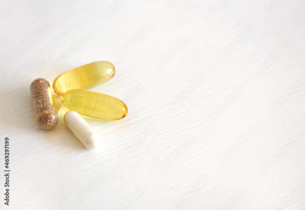 Close-up photo of a group of vitamins on a white background. Capsules ...
